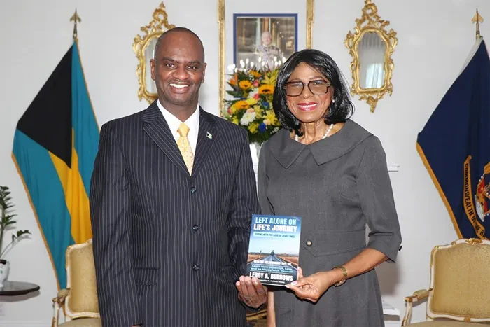 Leroy Burrows presents a copy of his book to the Governor Ge